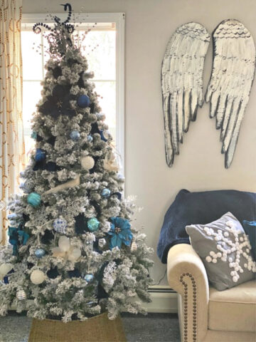 Elegant Flocked Christmas Tree With Blue And Silver Decorations